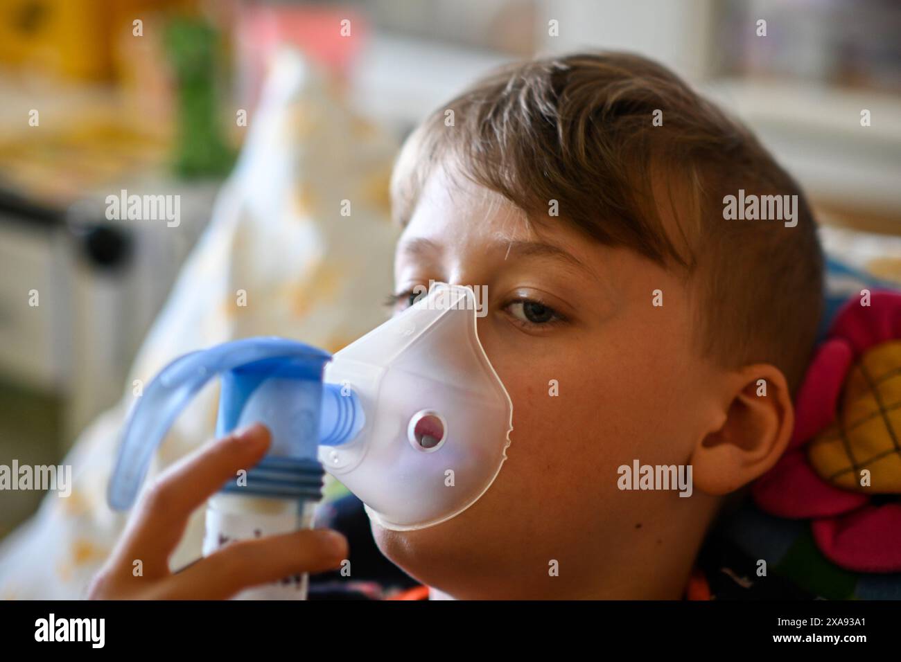 Child patient takes medication via an inhaler while sitting in a ...