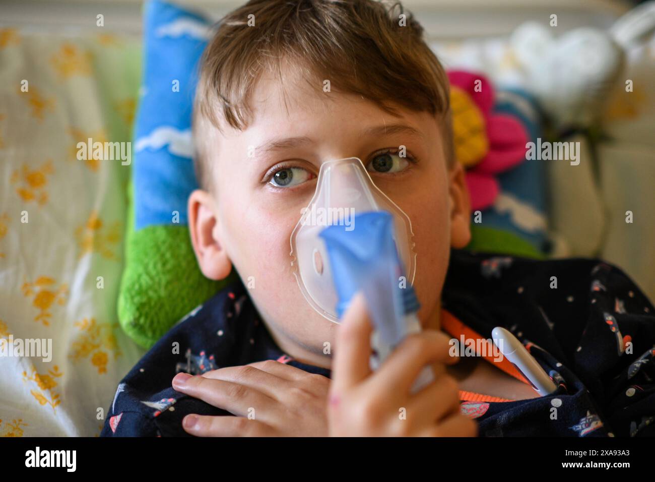 Child patient takes medication via an inhaler while sitting in a ...