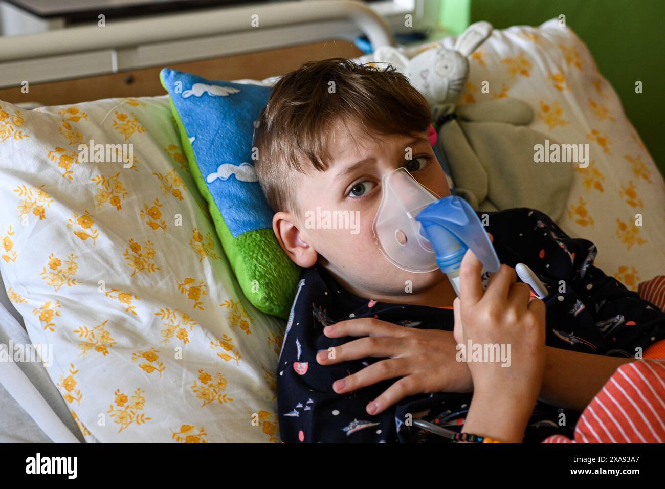 Child patient takes medication via an inhaler while sitting in a ...
