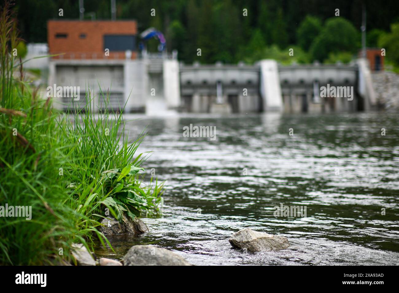 Small hydroelectric dam operates in a forested area, exemplifying ...