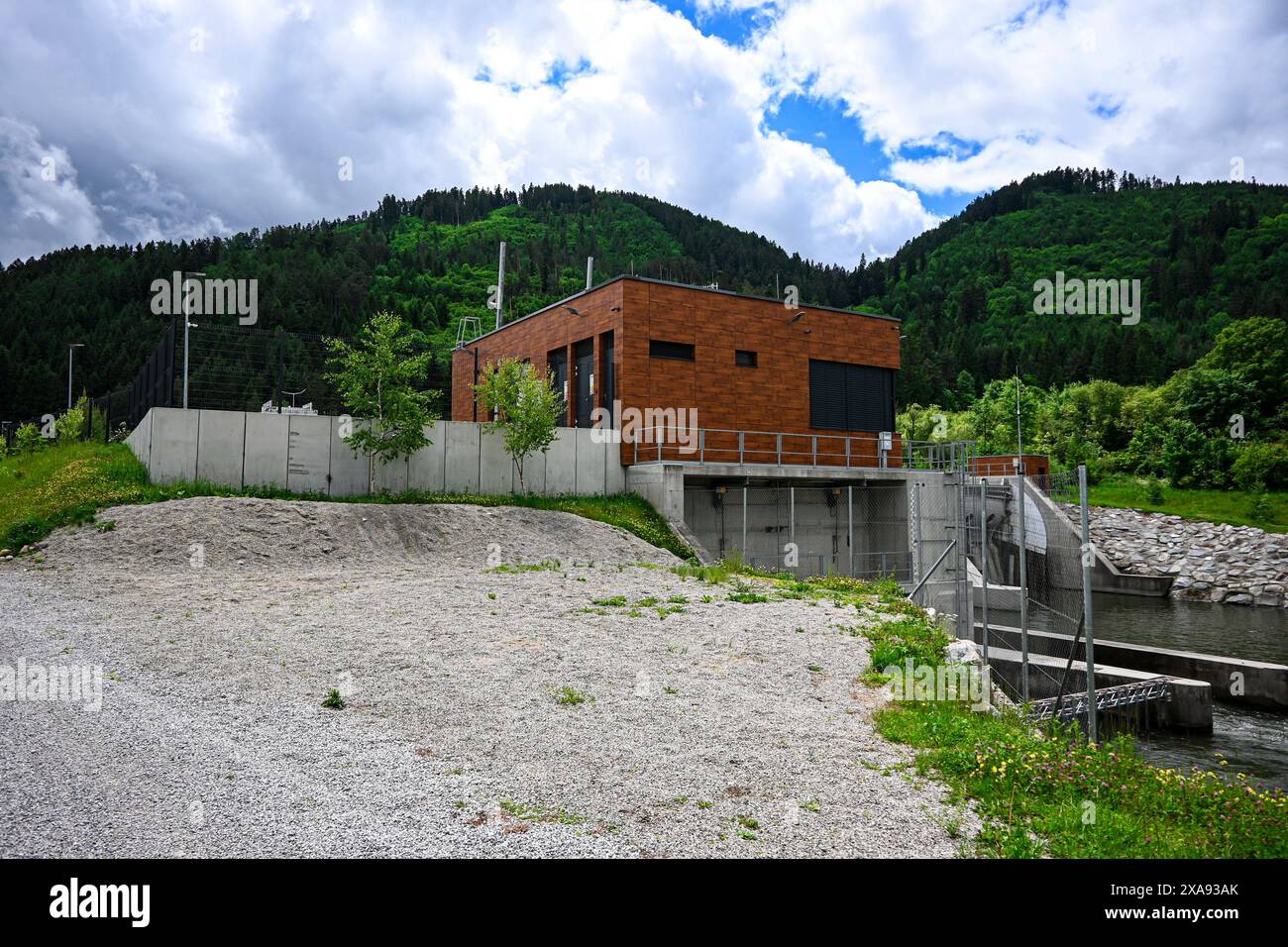 Small hydroelectric dam operates in a forested area, exemplifying ...