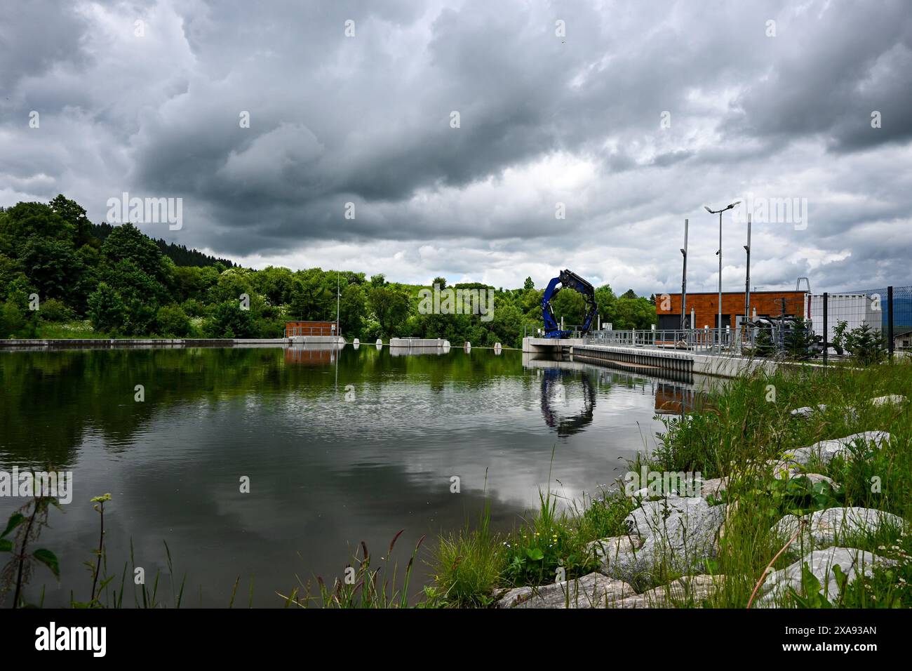 Small hydroelectric dam operates in a forested area, exemplifying ...