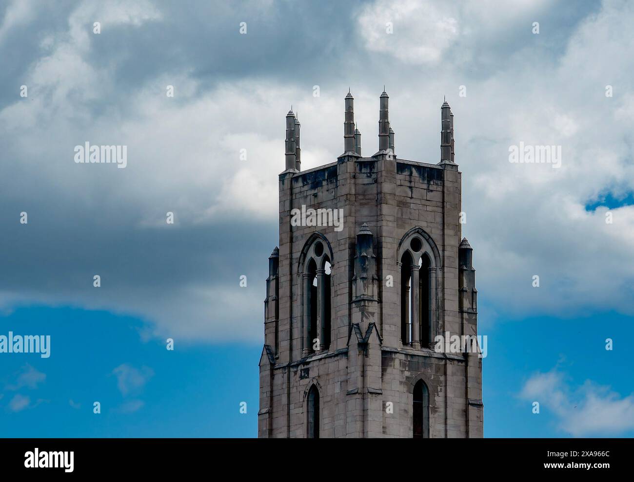 Norman style church steeple juts over a park Stock Photo - Alamy