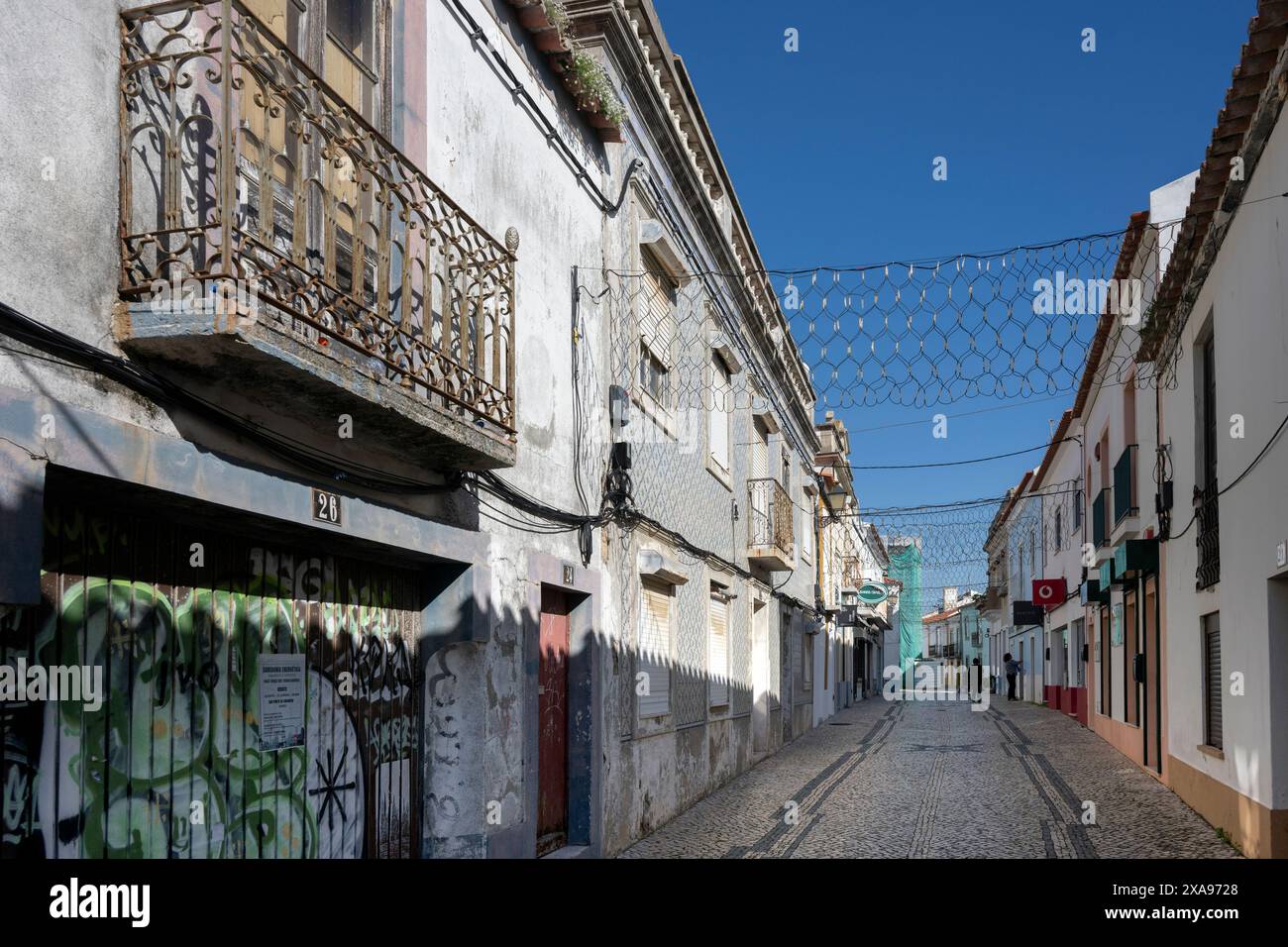 Cobblestone street in the Town of Sines, Setubal, Portugal that is also ...