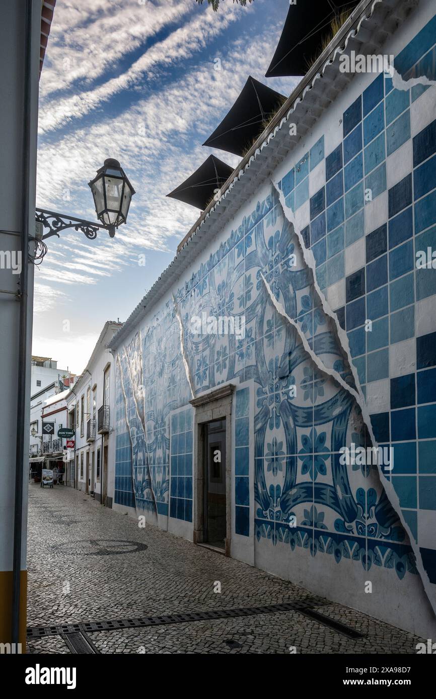 Blue tiled exterior wall of a building on a narrow cobblestone street ...