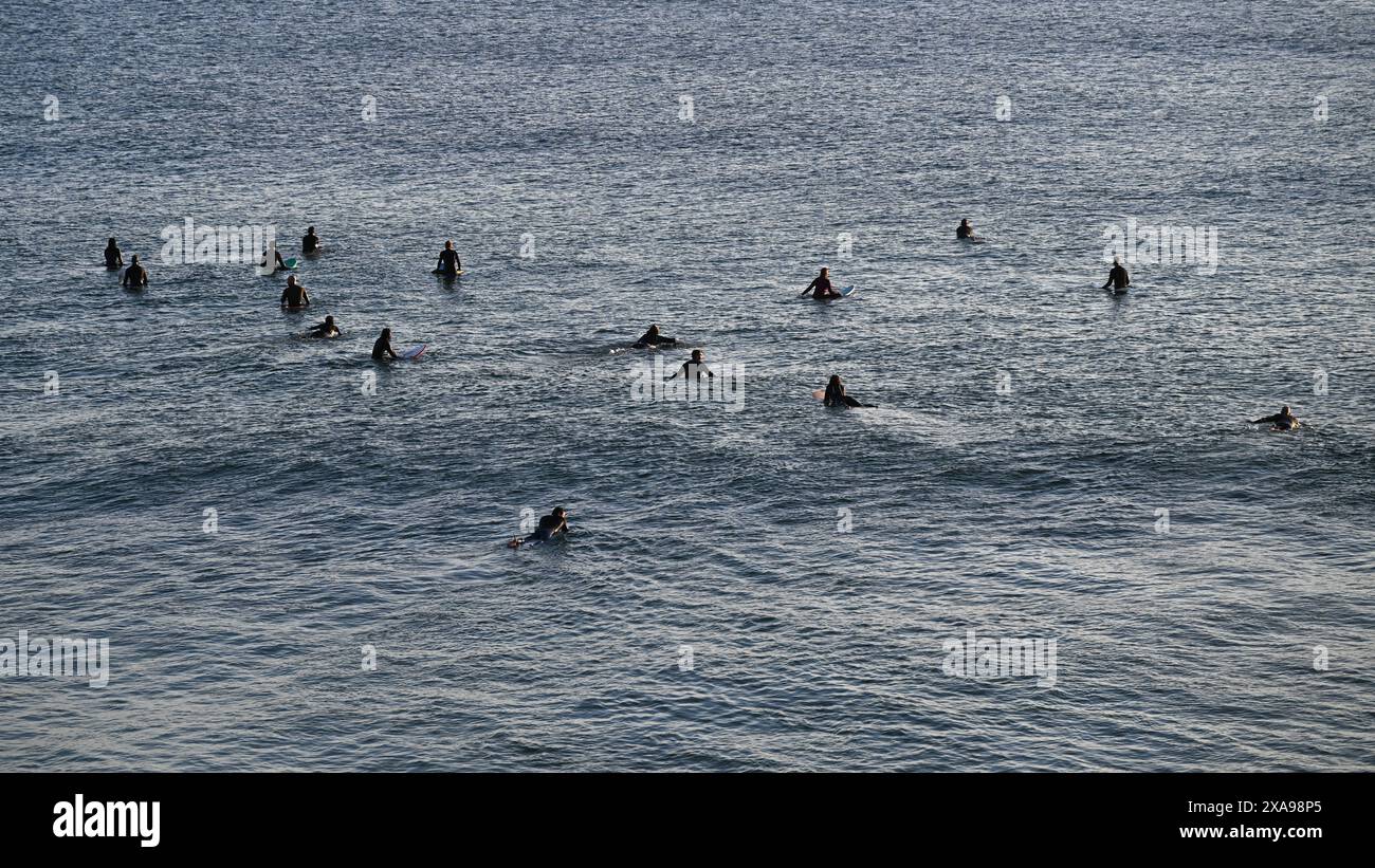 Swimmers in the ocean off the coastline along Praia do Zavial ...