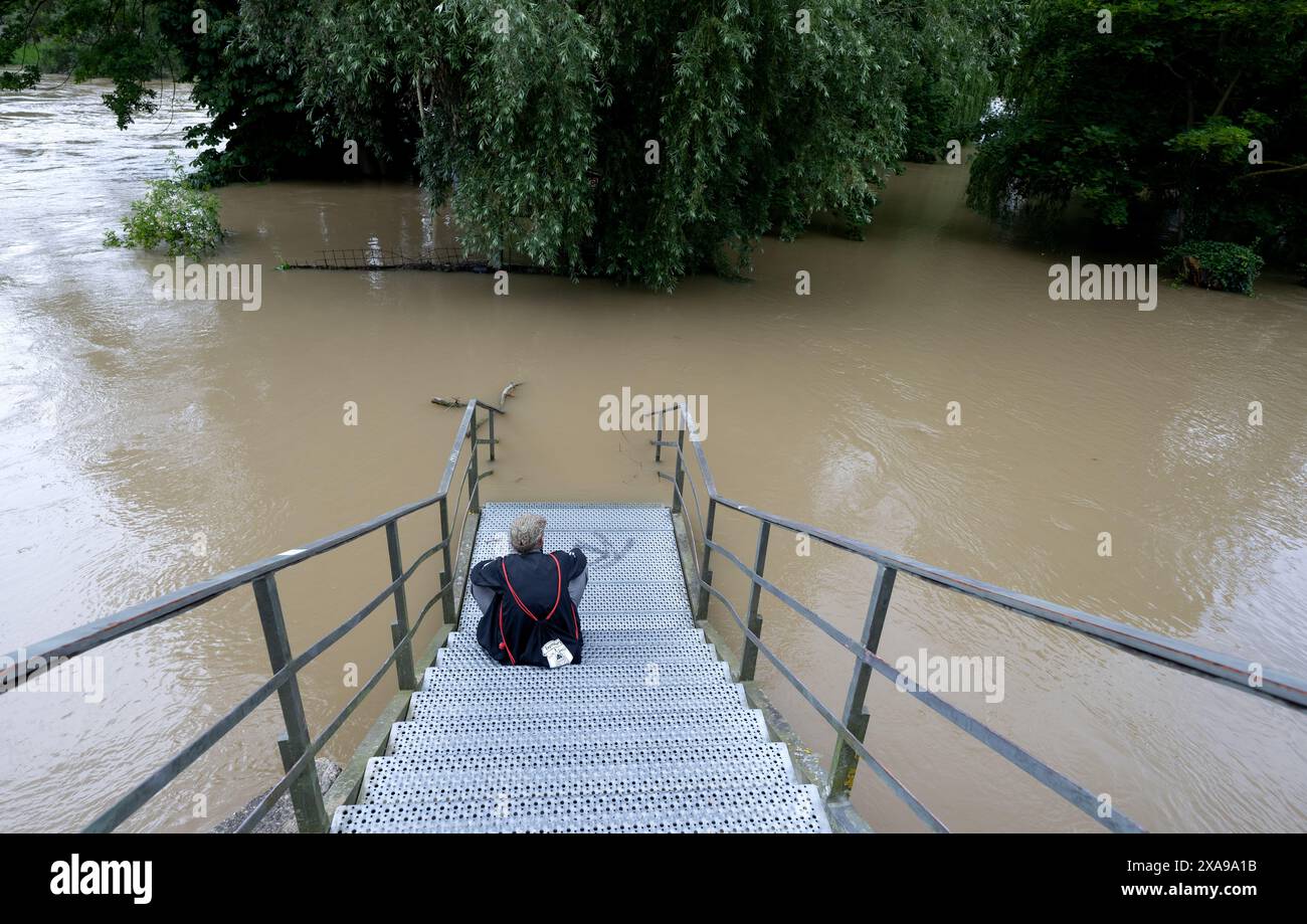 Regensburg, Germany. 05th June, 2024. A man sits on a flooded staircase ...