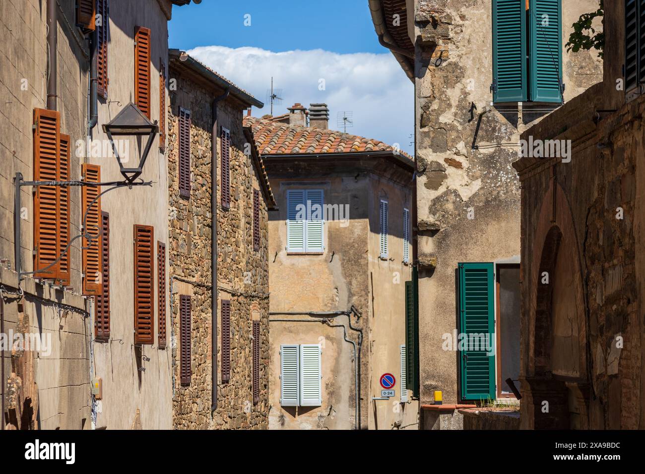 Terracotta rooftops, painted wooden shutters on windows and a street ...