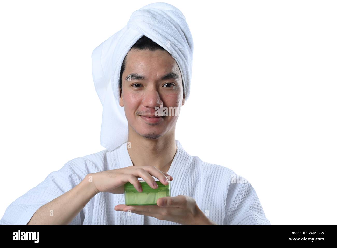 Portrait of handsome man in bathrobe holding a jar of aloe vera gel on ...