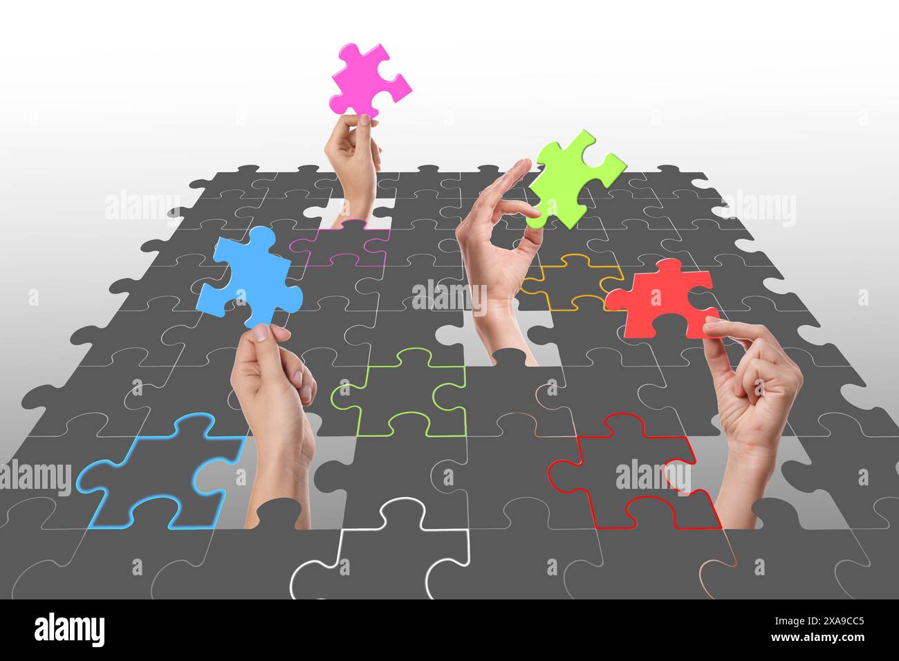 Hands with jigsaw puzzle pieces sticking out from combined elements ...