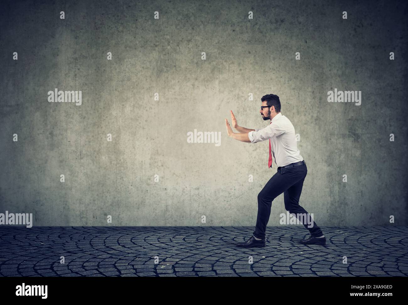 Business man pushing invisible obstacle Stock Photo - Alamy