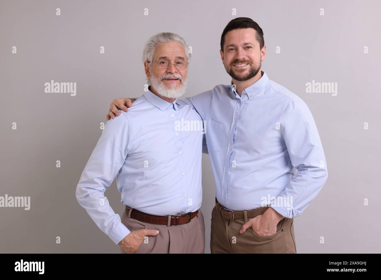 Happy son and his dad on gray background Stock Photo - Alamy