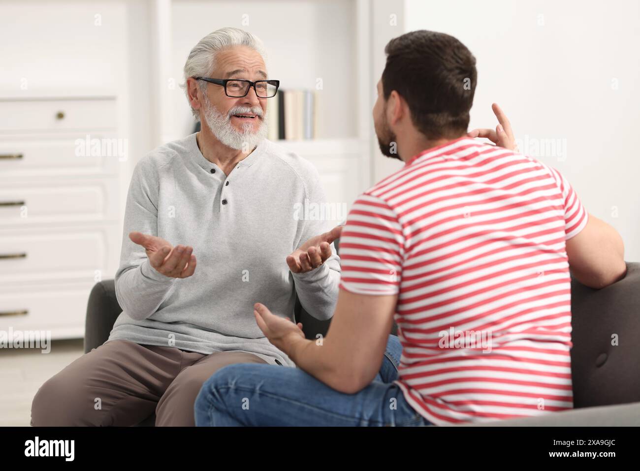 Happy son and his dad talking at home Stock Photo - Alamy
