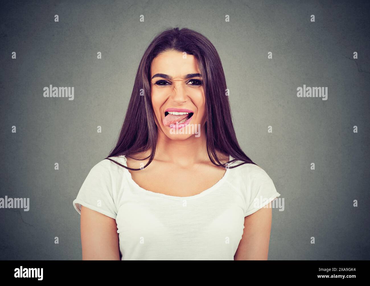 Portrait of a young woman sticking her tongue out Stock Photo - Alamy