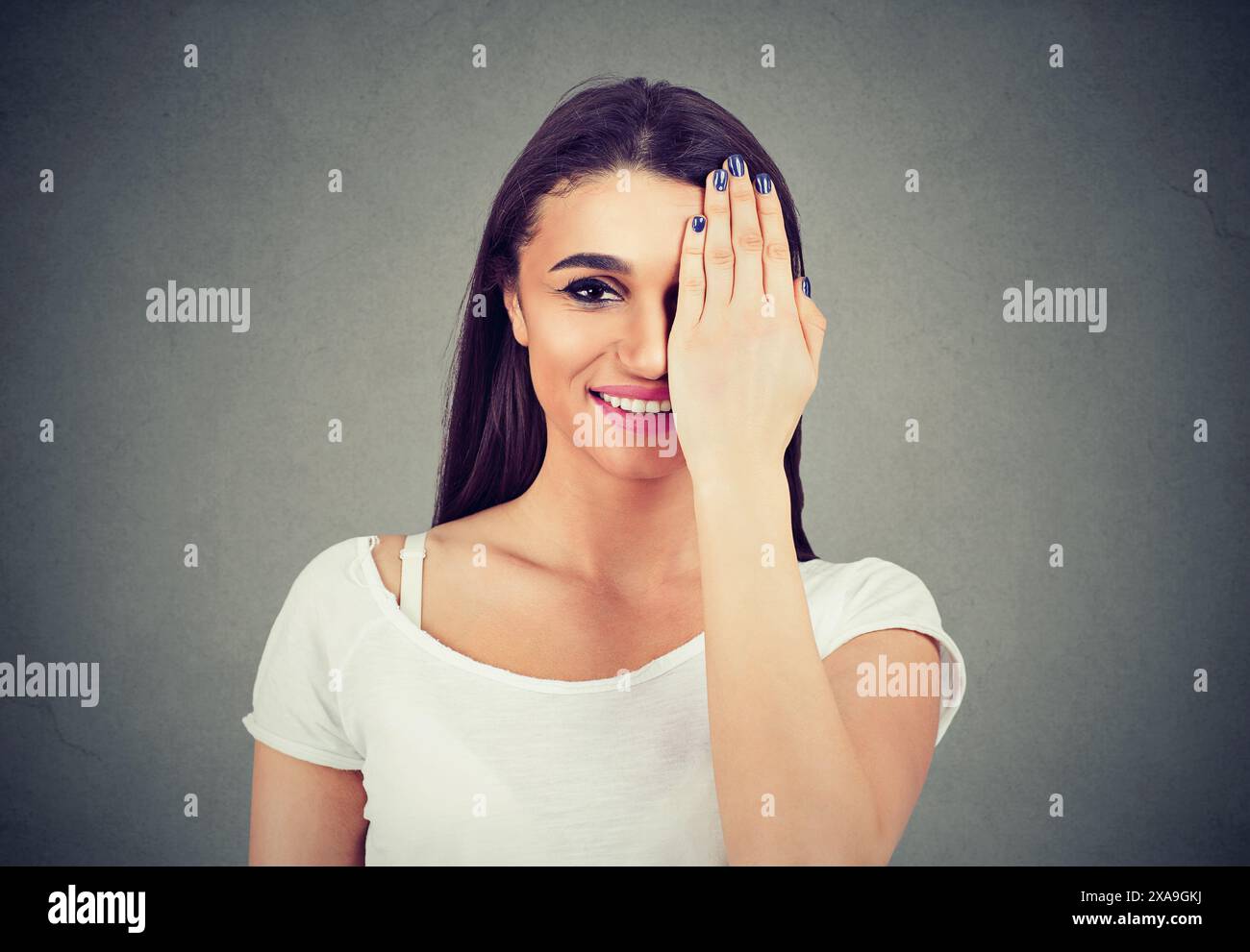 woman covering one eye with her hand as she looks at the camera with a ...