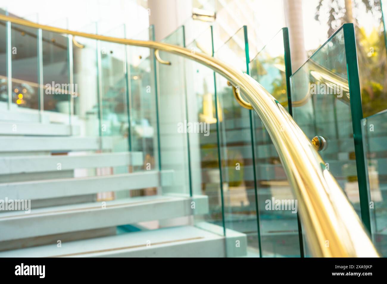 Modern glass staircase with a golden handrail, epitomizing contemporary ...