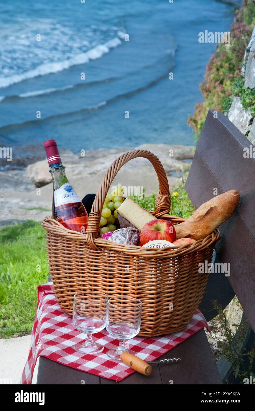 Picnic wicker hamper basket with French produce including rosé wine ...