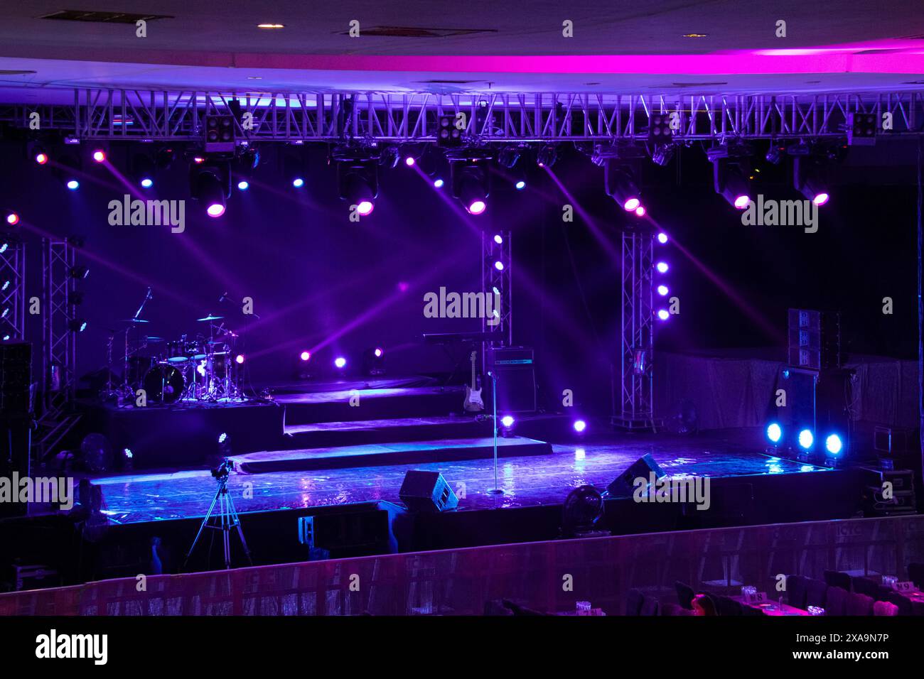 Illuminated concert stage with blue and purple lighting, fog effects ...