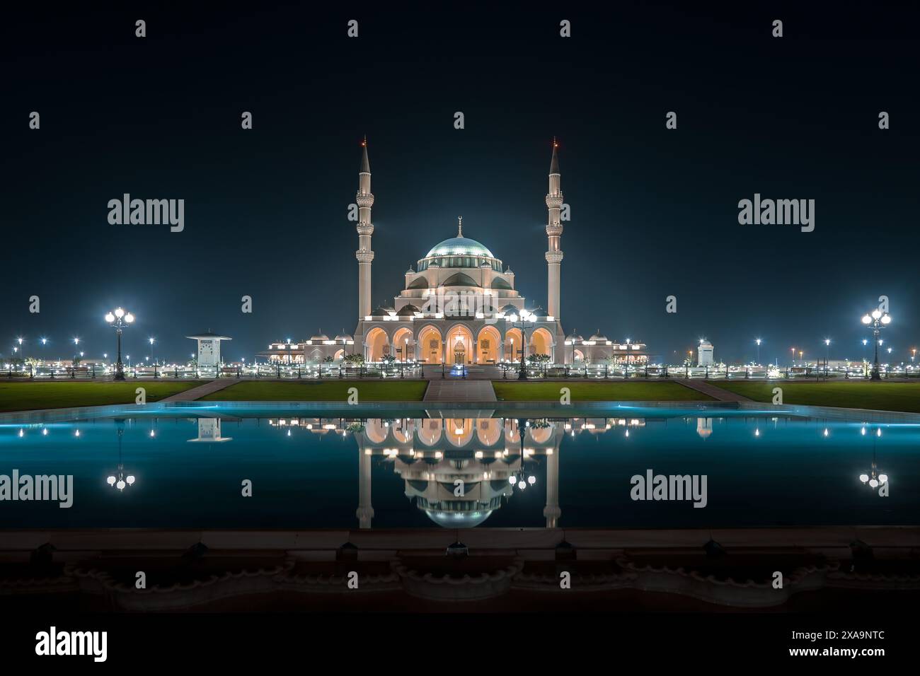 A mosque's illuminated reflection in a nighttime pond Stock Photo - Alamy