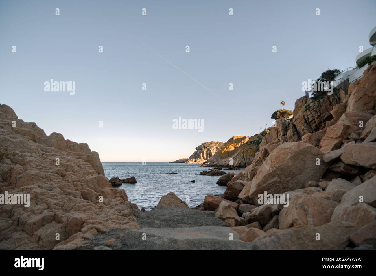 Steps and boulders on sandy shore by water's edge Stock Photo - Alamy