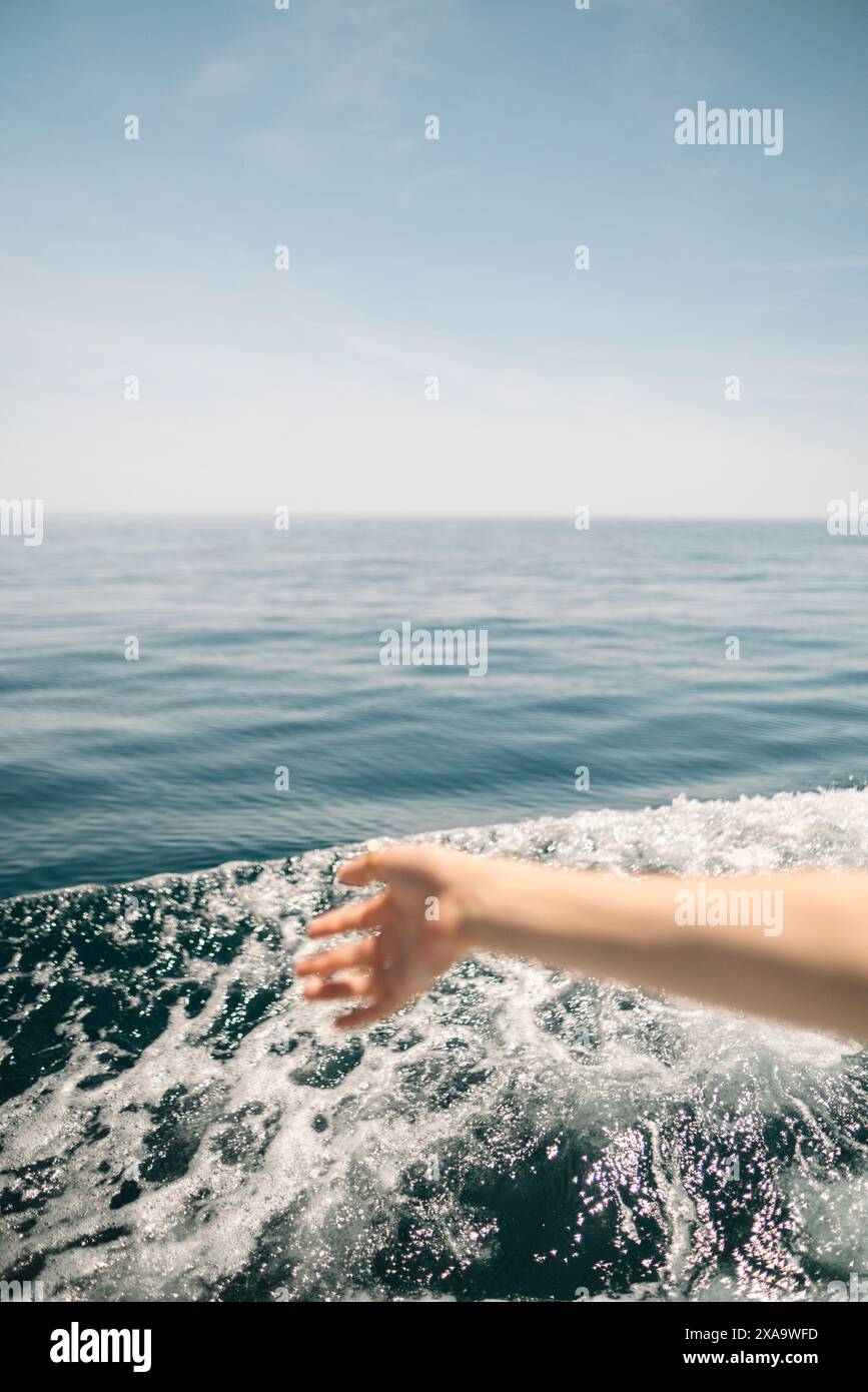 Hand waving above water near boat Stock Photo - Alamy