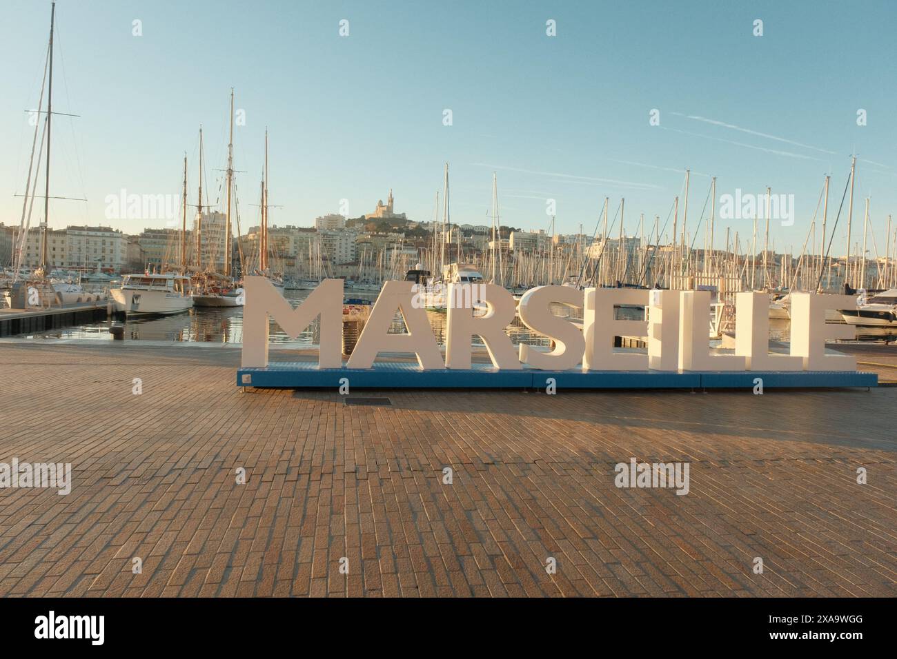 A Sign reading Marseille with white 3d letters near boats and urban ...