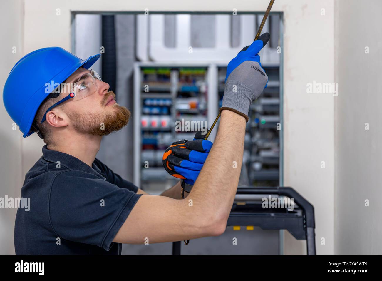 Electrician installing laying electrical cables on the ceiling inside ...