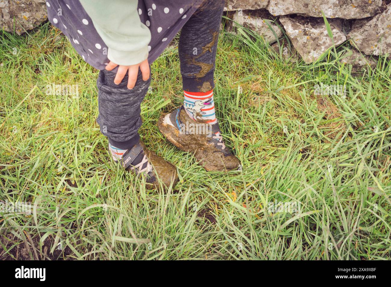 Girl showing off her muddy boots on a hike Stock Photo - Alamy