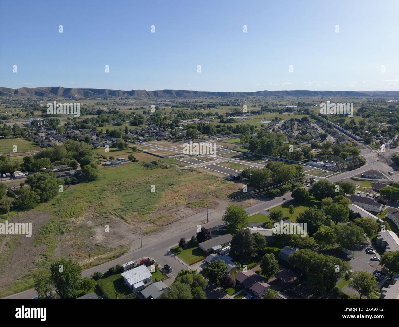 Aerial view of suburban neighborhood and mountains, with lush trees ...