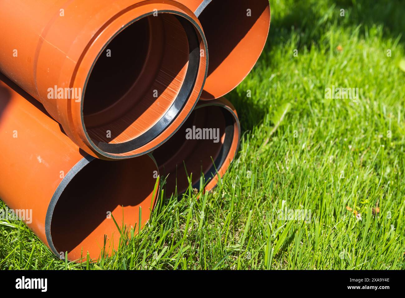Close up photo of pipes for external sewerage laying on green grass on ...