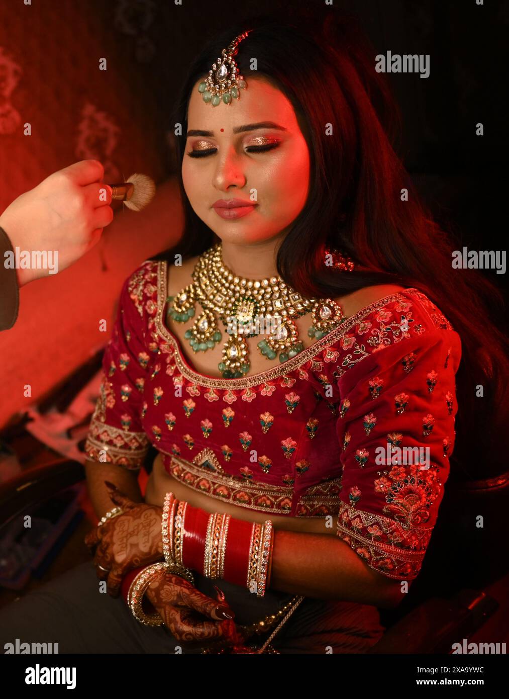 Indian bride sitting for makeup styling for wedding Stock Photo - Alamy