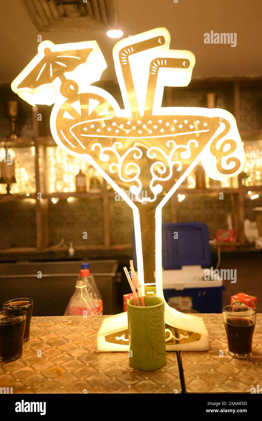 A glowing sign of a coctail on a table beside beverages Stock Photo - Alamy