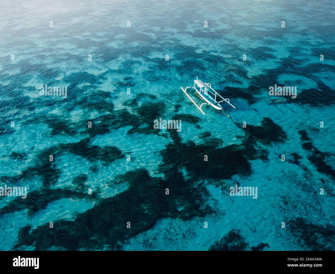 Fishing boat at anchor in blue transparent ocean in tropical island ...