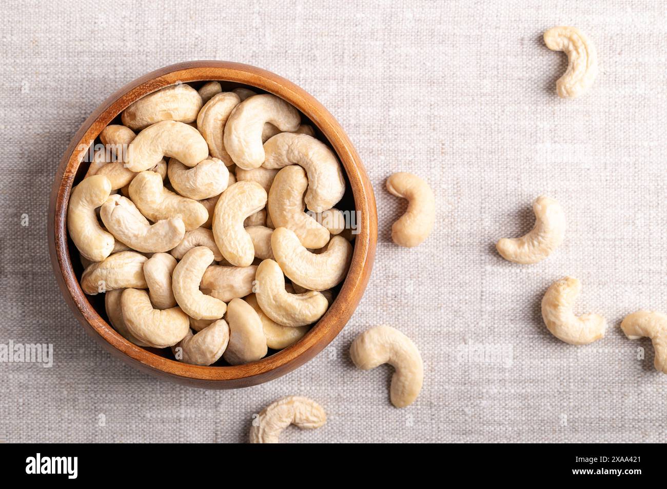 Cashew nuts, raw cashews in a wooden bowl on linen fabric. Seeds of ...