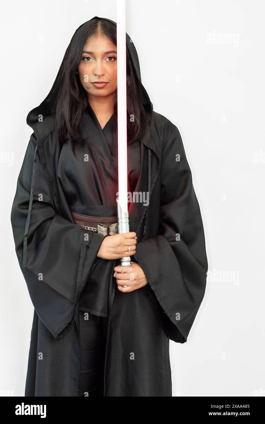 A sci-fi fantasy warrior woman cosplayer in a black robe holding a ...