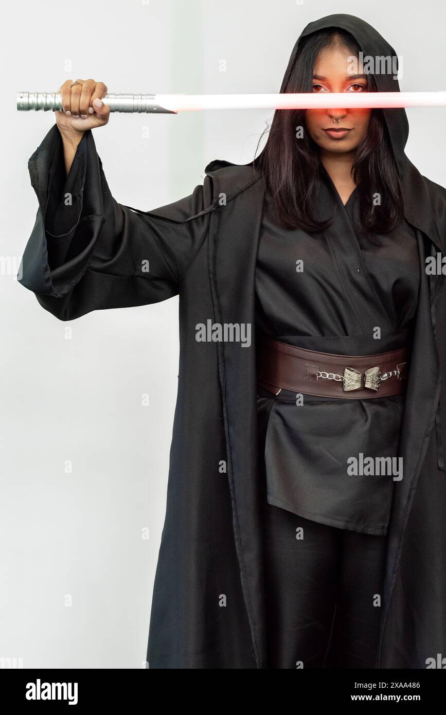 A sci-fi fantasy warrior woman cosplayer in a black robe holding a ...