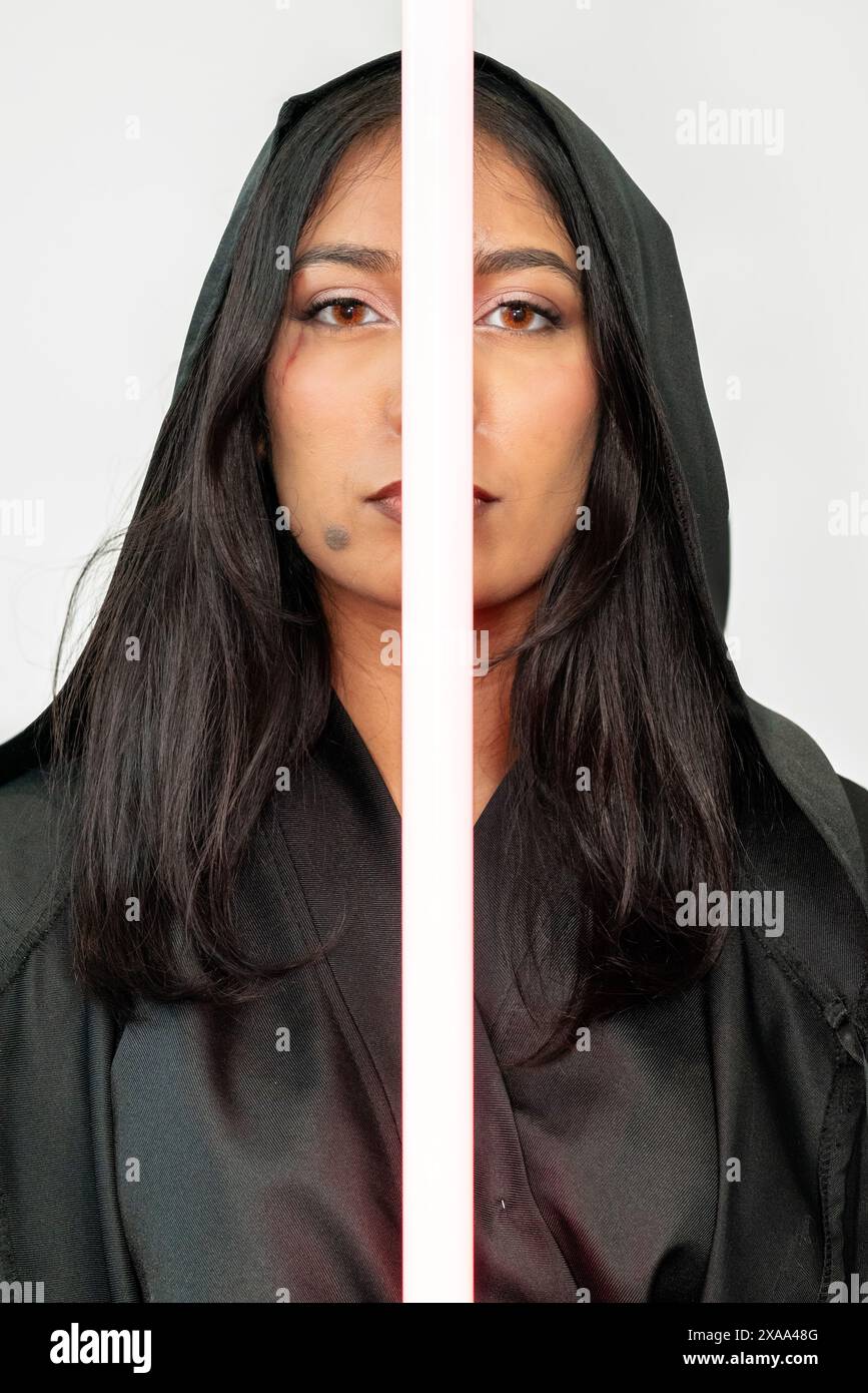 A sci-fi fantasy warrior woman cosplayer in a black robe holding a ...