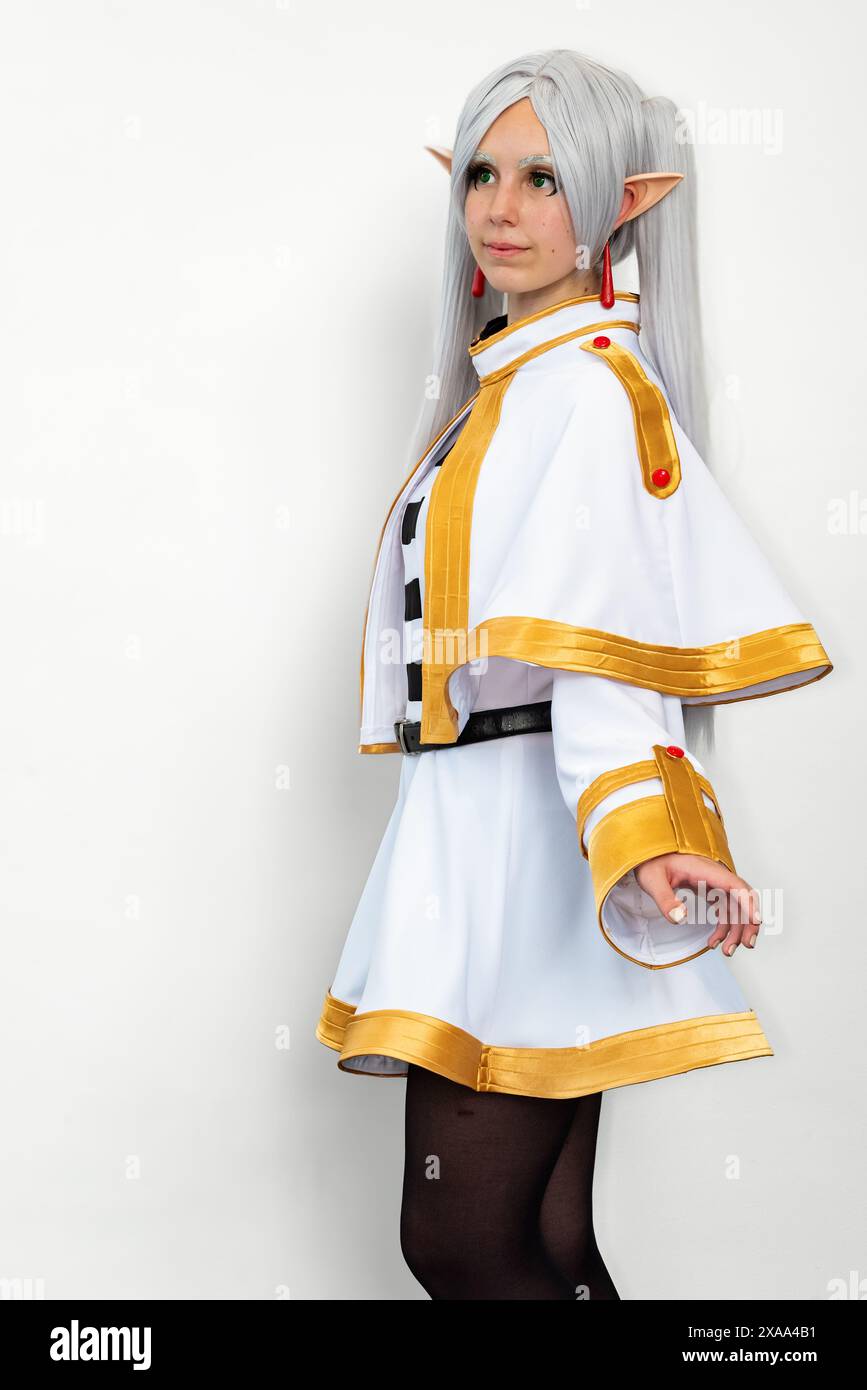 A female cosplayer dressed as an elf character with white hair on a ...