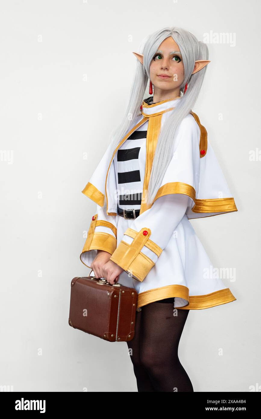 A female cosplayer dressed as an elf character with white hair on a ...