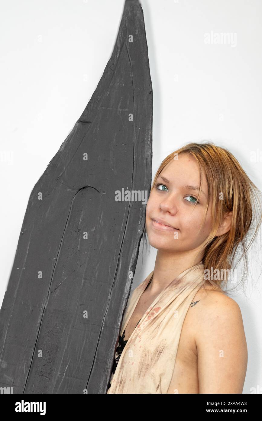 A female cosplayer in a horror outfit posing with a large blade sword ...