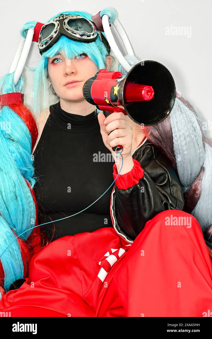 A female cosplayer dressed as an anime character with blue hair and a ...