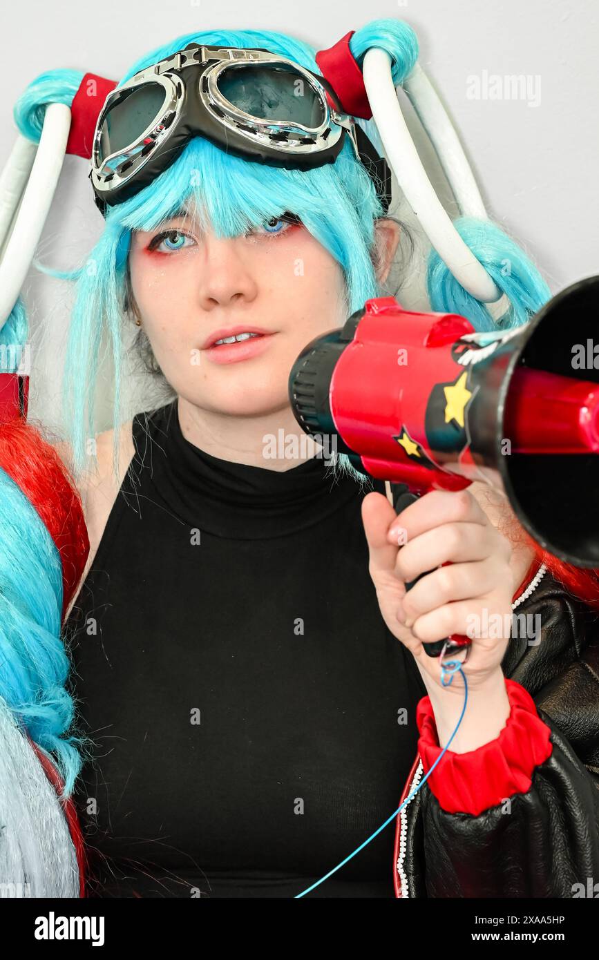 A female cosplayer dressed as an anime character with blue hair and a ...