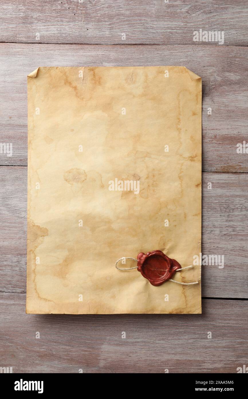 Sheet of old parchment paper with wax stamp on wooden table, top view ...