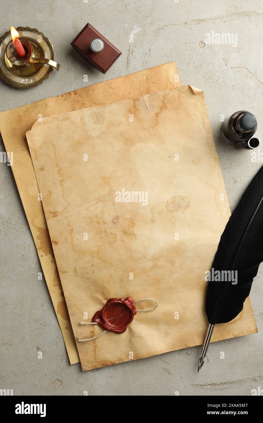 Sheet of old parchment paper with wax stamp, black feather, inkwell and ...
