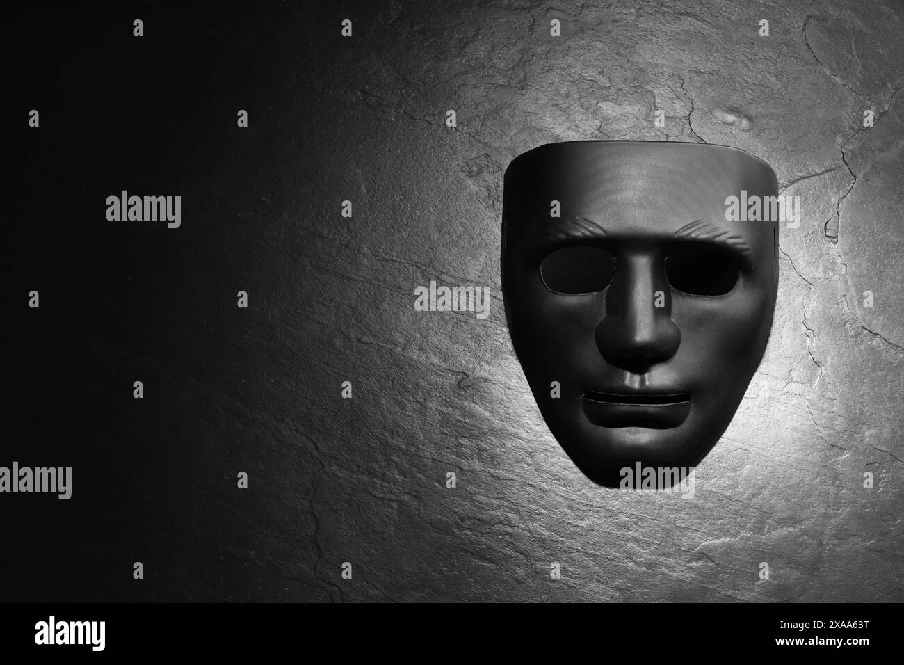 Plastic face mask on black slate surface, top view and space for text ...