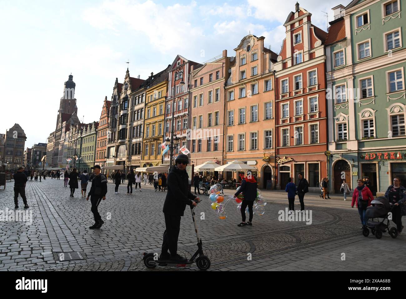 The people walking in the street of the colorful city center of Wroclaw ...