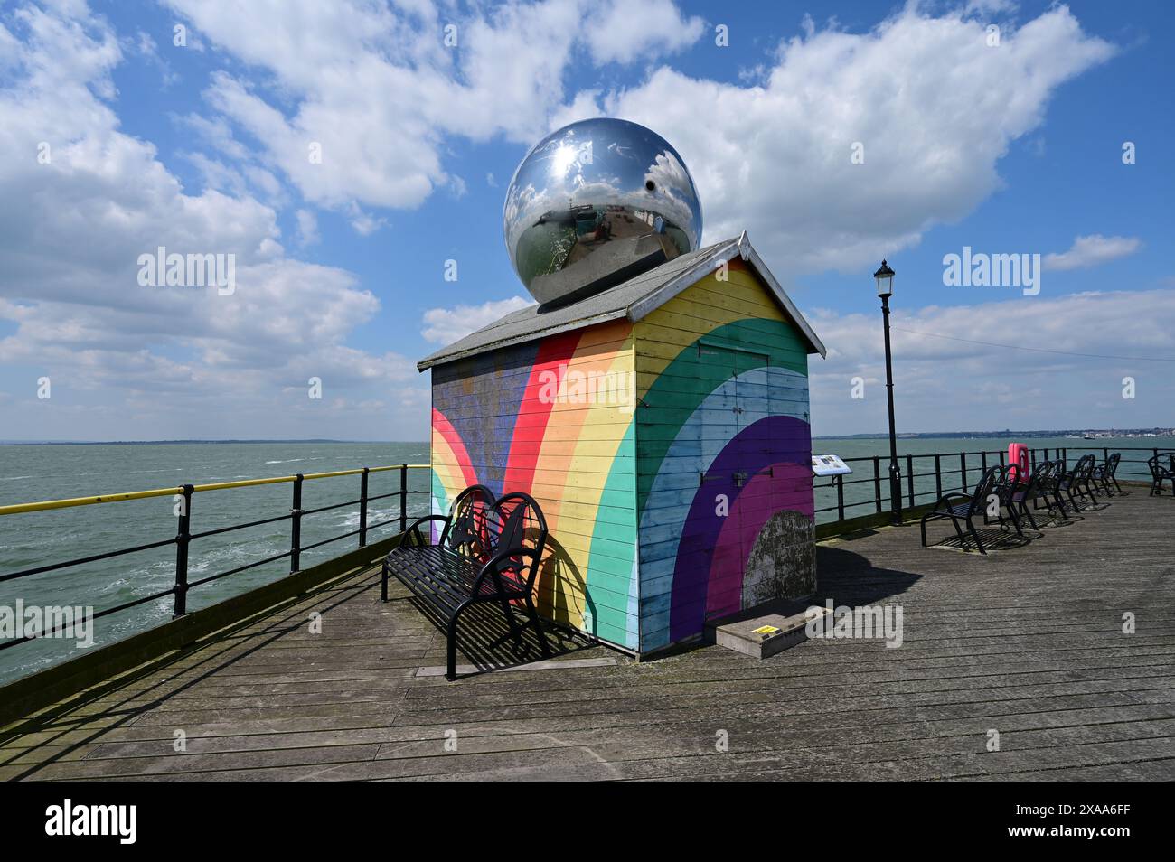 Rainbow coloured shed on a pier on the UK Stock Photo - Alamy