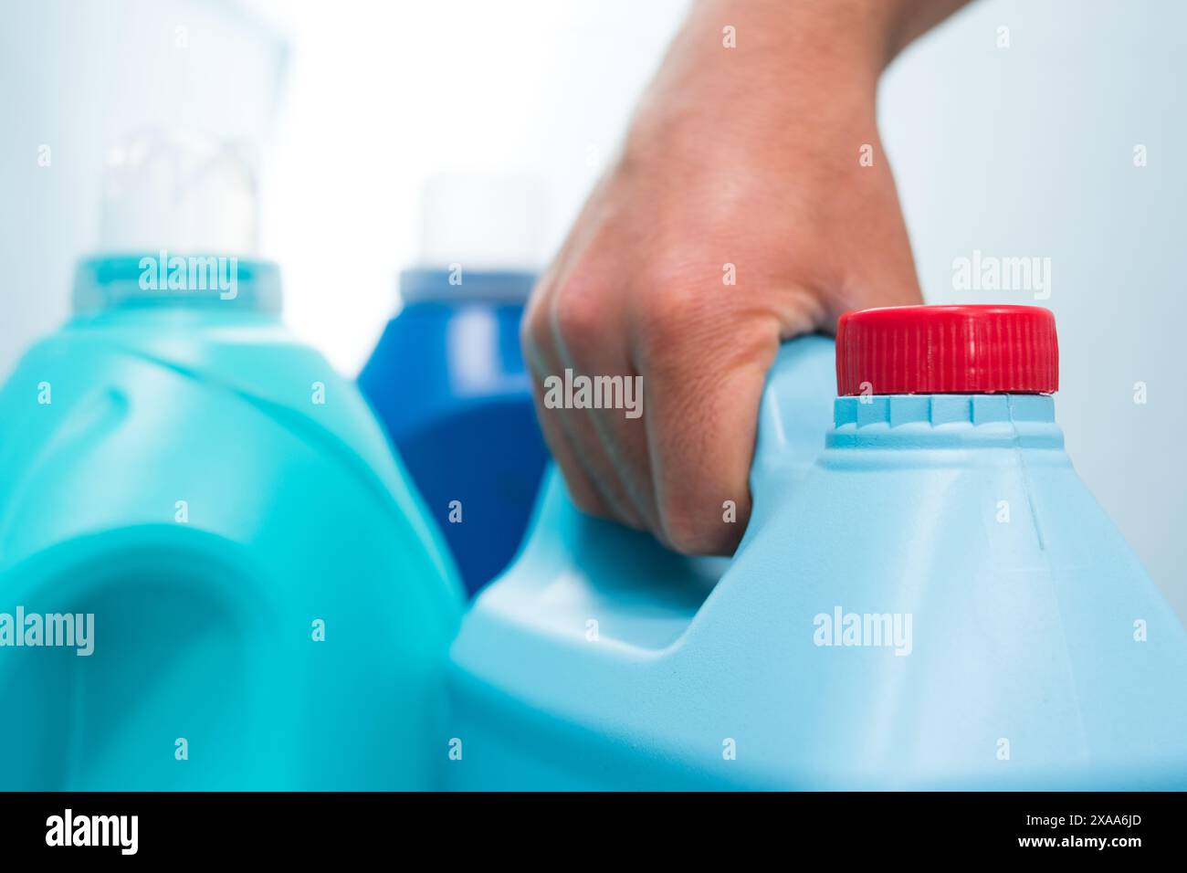 The hand is holding a blue container of cleaner Stock Photo - Alamy