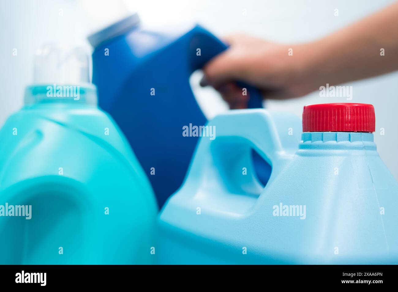 The hand is holding a blue container of cleaner Stock Photo - Alamy