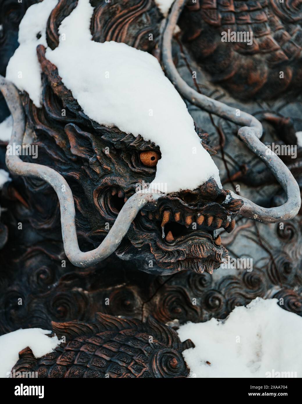 A menacing dragon statue covered in snow at the ancient sacred ...